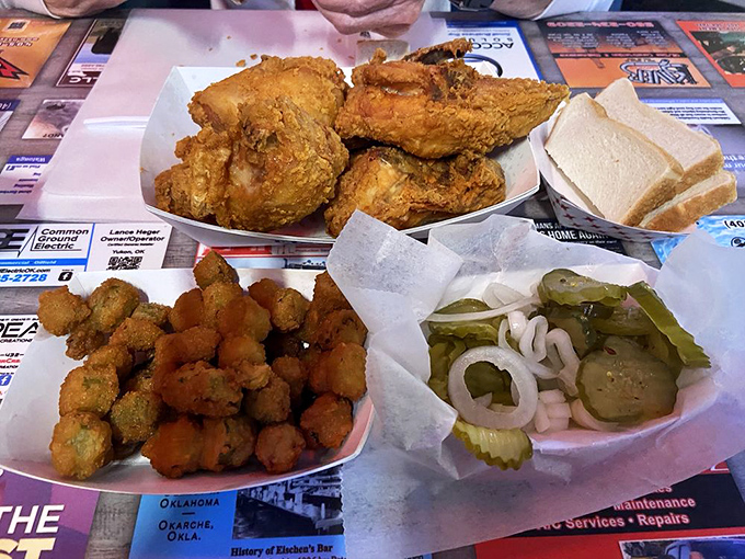The complete Eischen's experience: golden chicken, crispy okra, and pickles all sharing the spotlight on a paper-lined platter.