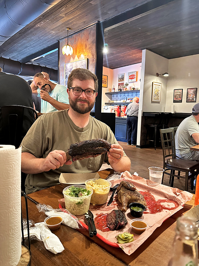 The universal language of BBQ joy, spoken fluently by this diner whose rib-holding technique suggests he's achieved meat nirvana.