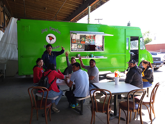 The vibrant green "Don Pancho" food truck serves as both kitchen and community center, where strangers become friends over authentic flavors.