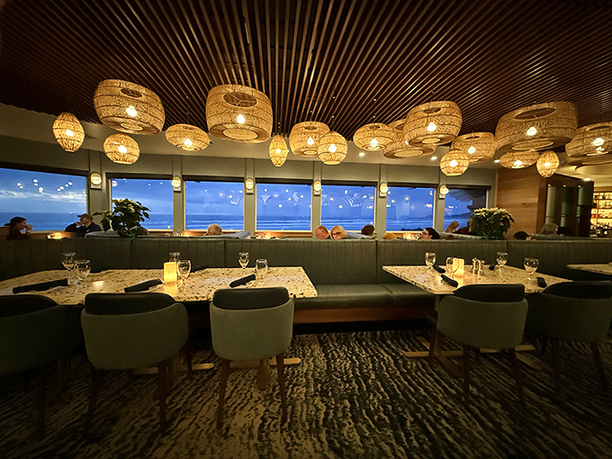 Twilight transforms the dining room into a magical space where ocean views compete with plates for your attention. The pendant lights win after dark.
