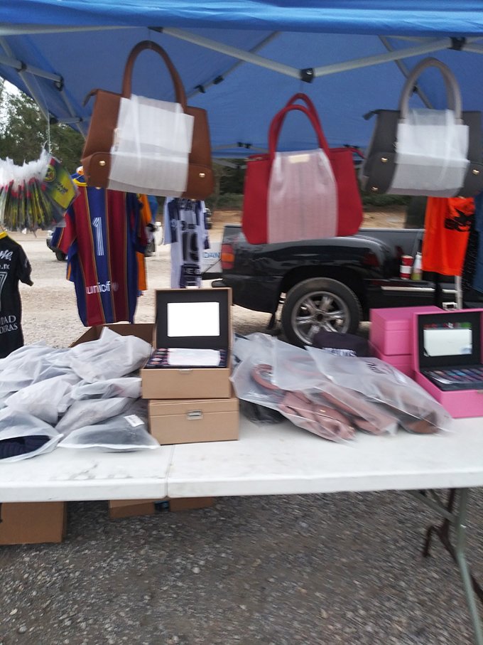 Designer-inspired handbags hang hopefully in the Kansas breeze. That brown tote is practically begging to carry your other flea market finds.