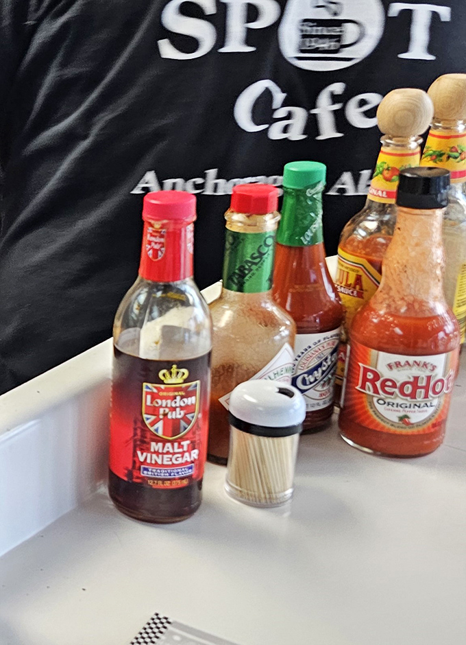 The condiment lineup: silent heroes of any great meal. From malt vinegar to hot sauce, these bottles stand ready to elevate your experience.