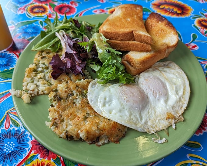 Comfort food gets a gourmet upgrade. Crispy-edged eggs, golden toast, and what appears to be a delicious hash &ndash; breakfast perfection on a colorful plate.