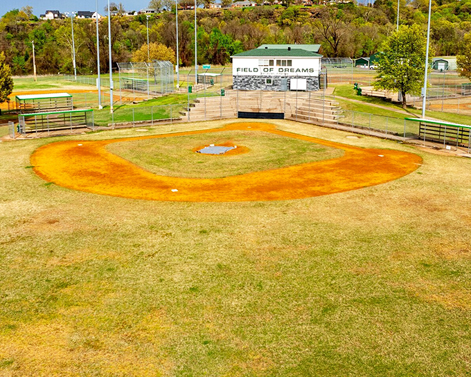 The baseball field stands ready for games where families can afford hot dogs without refinancing their homes.