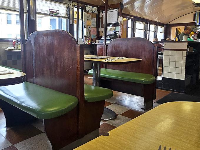 The wooden booths with mint green seats aren't just furniture—they're front-row tickets to the greatest breakfast show in Pawtucket, complete with checkered floor.
