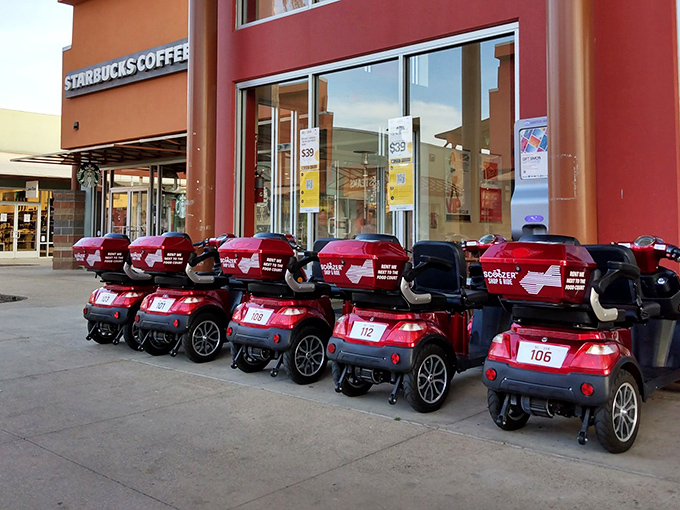 The mall's mobility scooters lined up like tiny red chariots, ready to rescue shoppers whose ambitions exceeded their endurance.