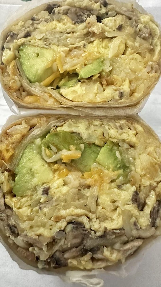 The burrito reveals its secrets in cross-section—a treasure map of avocado, eggs, and mushrooms wrapped in a warm tortilla blanket.