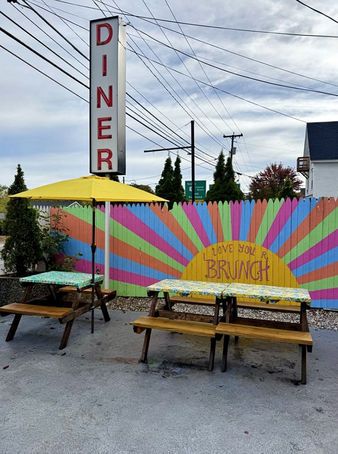 "I Love You A Brunch" declares the rainbow fence—outdoor seating where Maine summer days transform ordinary breakfasts into special occasions.