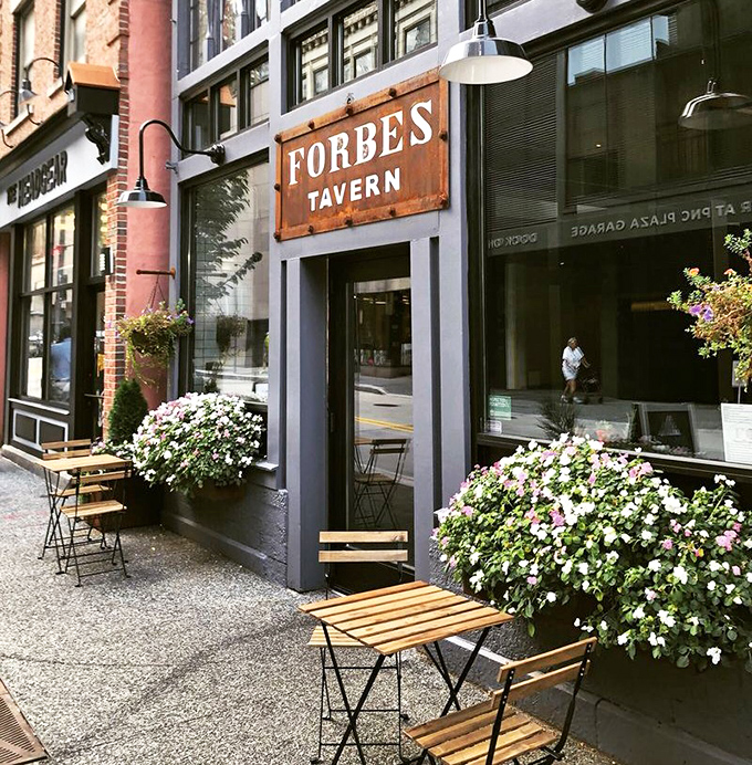 The tavern's exterior in daylight reveals thoughtful touches – flower boxes softening the urban landscape, inviting you to pause and come inside.