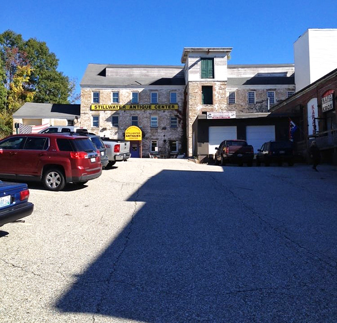 The parking lot view reveals the true scale of this stone treasure chest, where cars wait patiently while their owners lose track of time inside.
