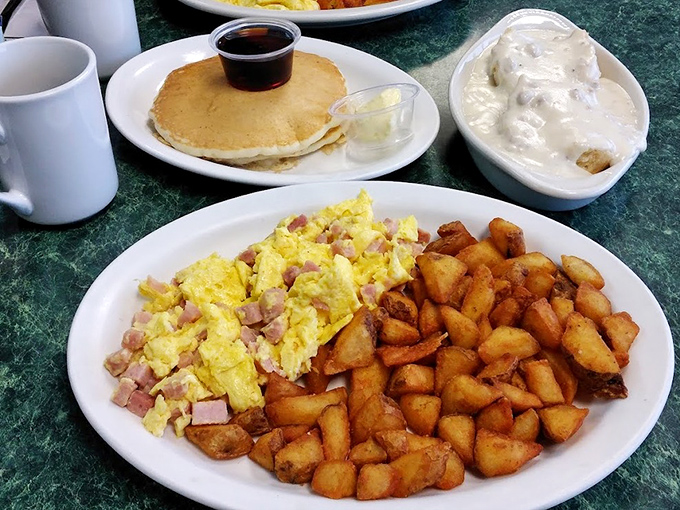 The Senior Breakfast Combo proves good things come in threes: fluffy scrambled eggs with ham, golden home fries, and a pancake for good measure.