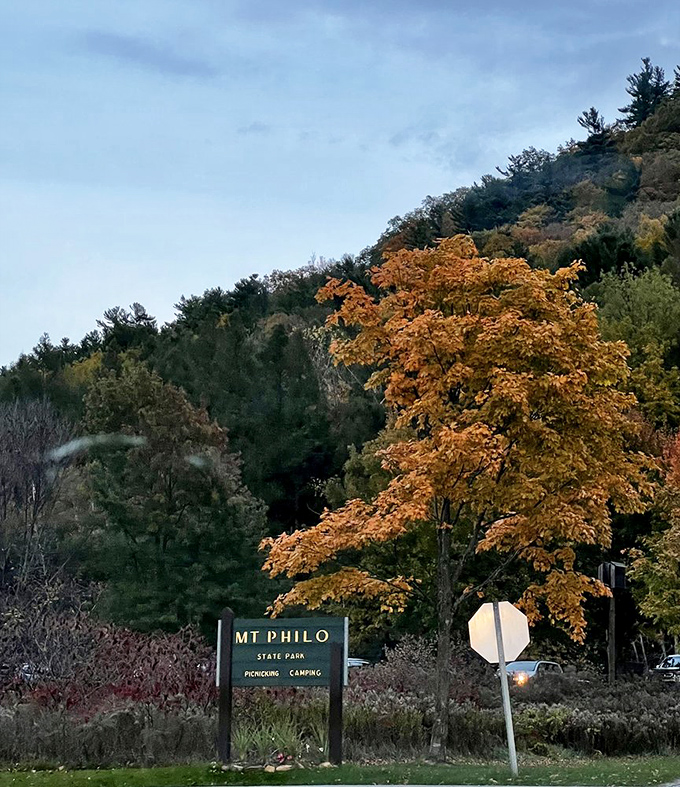 The park entrance sign stands like a promise of adventure, framed by Vermont's famous fall foliage.