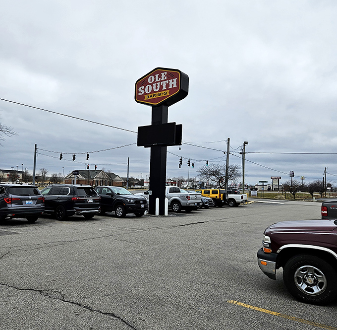 The roadside sign stands like a beacon of hope for travelers whose stomachs have GPS coordinates set to "authentic barbecue."