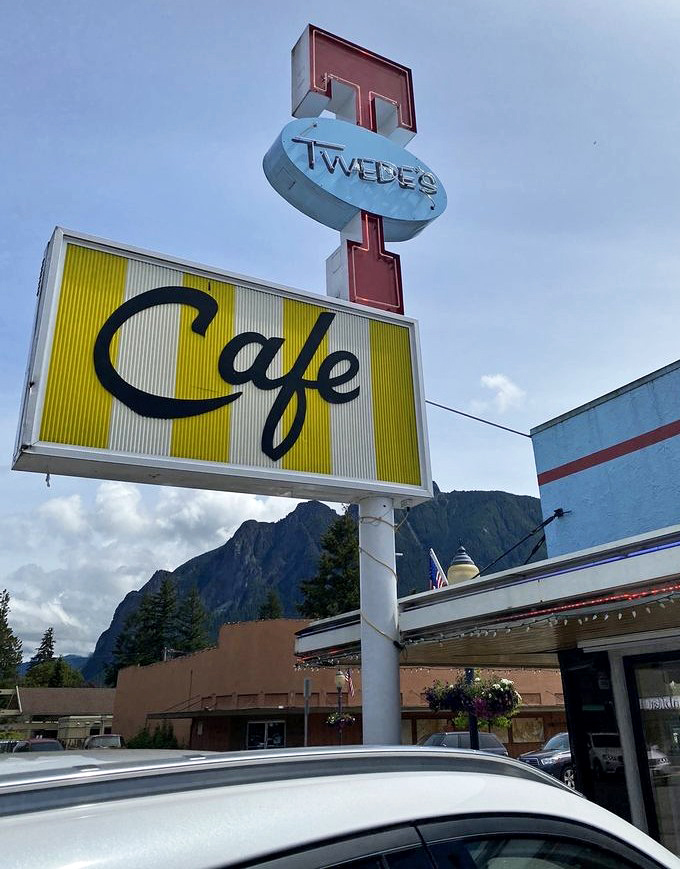 That iconic yellow and red sign stands like a beacon of hope for hungry travelers—a North Bend landmark against a mountain canvas.