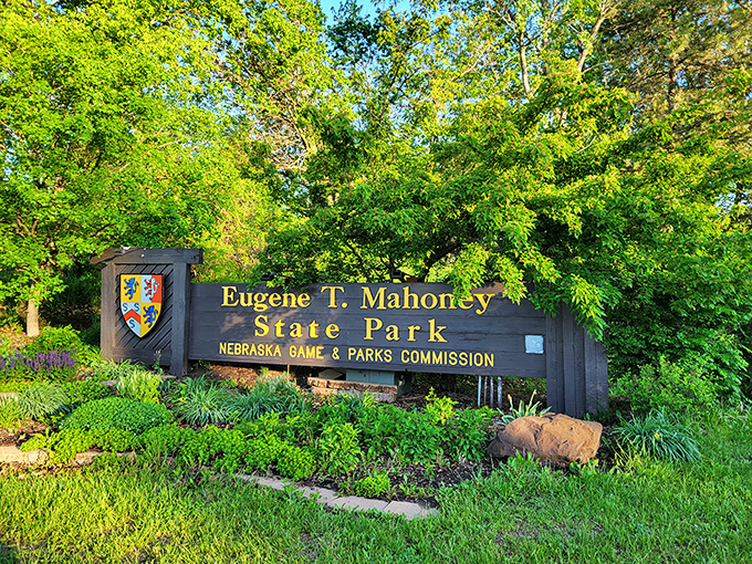 The park entrance sign, framed by lush greenery, promises adventures that will have you planning your return visit before you leave.