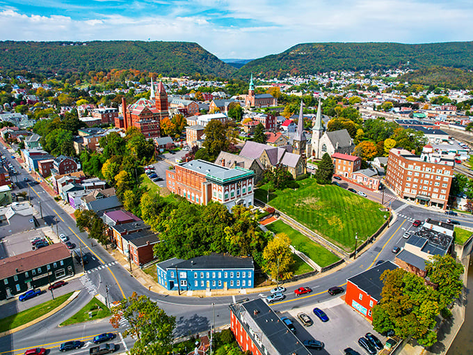 Cumberland unfolds like a miniature model village from above, nestled perfectly between protective mountain sentinels.