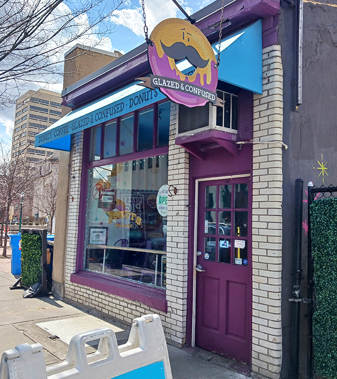 The purple door and bright blue awning stand out against white brick, like a colorful punctuation mark in the urban paragraph.