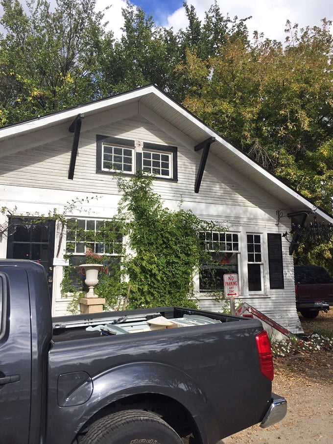 The white cottage exterior viewed from another angle reveals the unassuming nature of this treasure trove &ndash; proving that magic often hides in plain sight.
