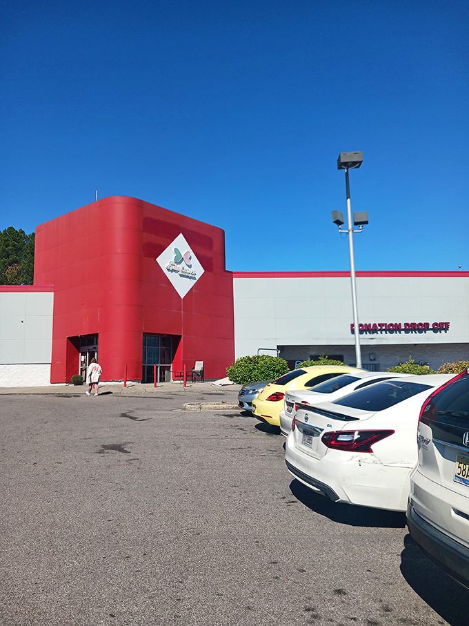 The distinctive red corner entrance stands like a cardinal against blue sky, welcoming treasure hunters to this secondhand wonderland.