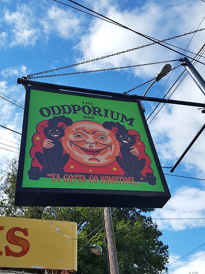 The hanging sign featuring that distinctive grinning face and black cats declares, "Ya gotta go sometime..." An invitation you can't refuse.