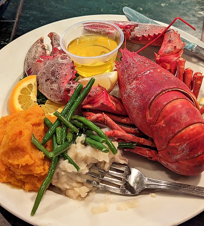 A whole Maine lobster in all its crimson glory, accompanied by drawn butter and sides that know their supporting role in this oceanic drama.