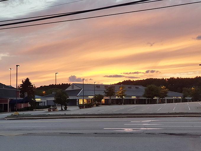 Sunset casts a golden glow over Kittery's buildings and empty parking lot &ndash; a rare moment of calm before tomorrow's shopping storm begins.
