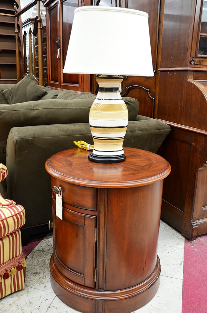 This polished side table topped with a striped ceramic lamp offers instant sophistication. Mid-century modern meets contemporary in perfect harmony.