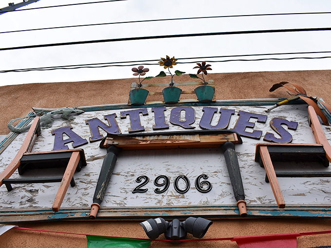 The weathered sign stands like a sentry, metal flowers keeping watch&mdash;2906 isn't just an address, it's the coordinates to your next great find.