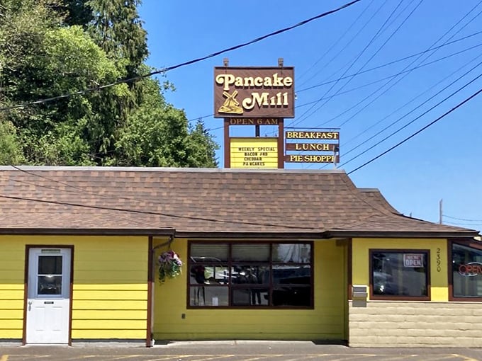 The roadside sign stands tall like a carbohydrate beacon, promising three essential food groups: breakfast, lunch, and pie. The holy trinity of dining.