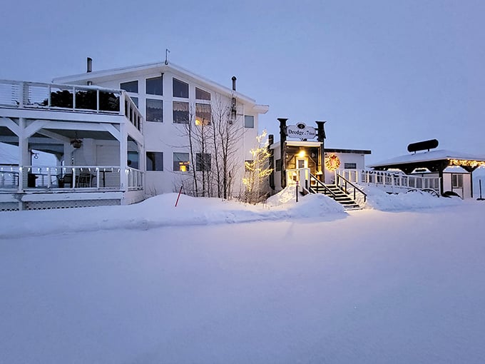 Winter transforms Nome into a snow-globe wonderland where cozy lights beckon travelers in from the polar night.