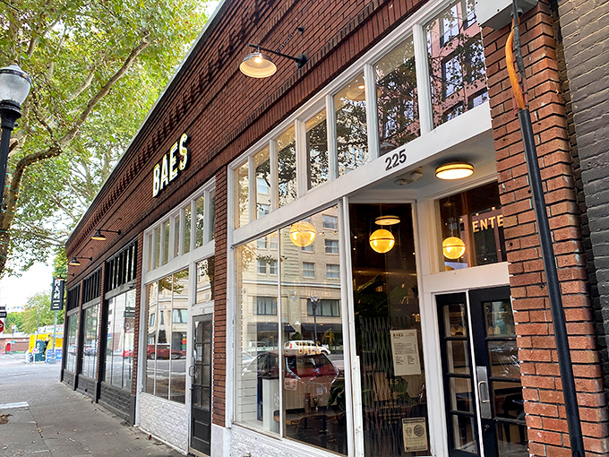 BAES storefront beckons with its warm brick facade. Those golden globe lights promise chicken treasures waiting inside.