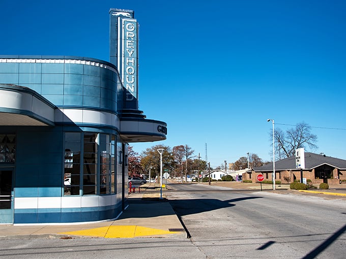 The Orpheum Theater in Blytheville stands like a time capsule from the golden age of cinema, its art deco sign reaching skyward against the clear Arkansas blue.