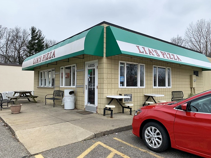 Sometimes the most unassuming buildings hide the greatest treasures. This cozy spot with its green awning promises pizza magic inside!