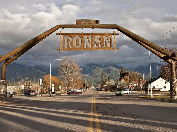 Ronan's iconic wooden arch welcomes visitors with rustic charm. Mountains stand guard in the background like nature's own welcoming committee.