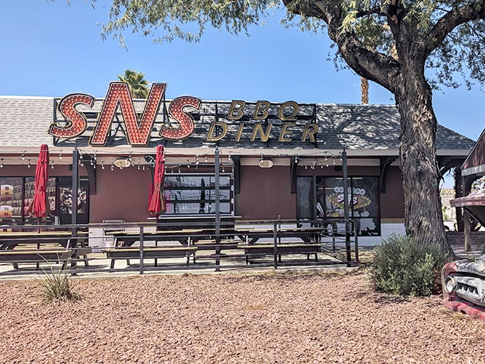 The iconic SNS BBQ Diner sign beckons hungry travelers like a neon-lit barbecue lighthouse. Simple outside, serious smoke inside!