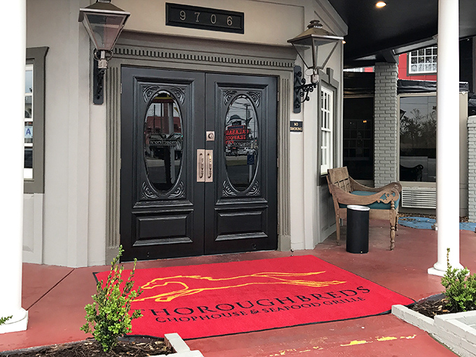 The elegant entrance to Thoroughbreds beckons with its red carpet welcome. Those double doors promise a steak experience worth dressing up for.