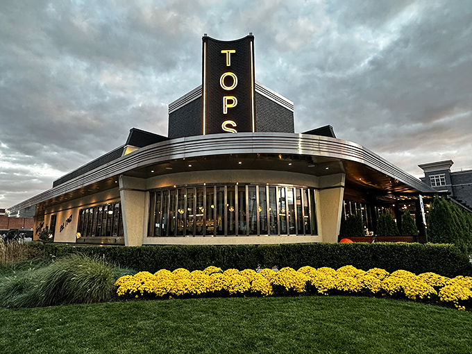 The iconic Tops Diner glows at dusk, its Art Deco curves and neon sign promising comfort food that's anything but ordinary.