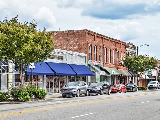 Brick storefronts and blue awnings create a timeless Main Street where your retirement dollars stretch like saltwater taffy.