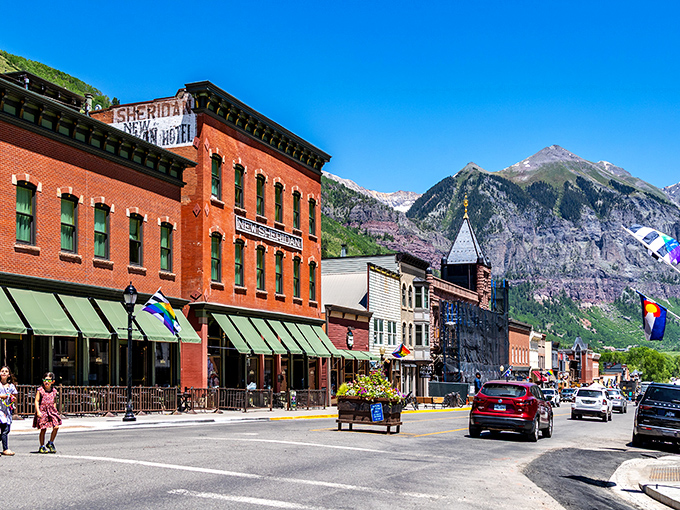 Historic brick buildings stand like proud sentinels, framing Colorado's dramatic mountain backdrop with timeless elegance.