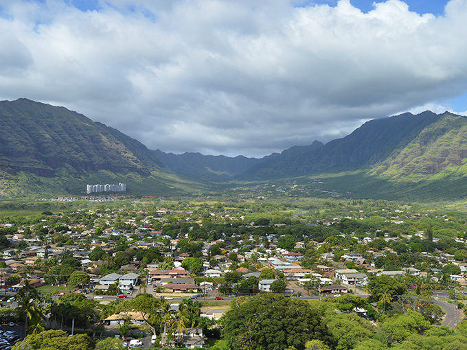 Neighborhood homes nestle against the dramatic backdrop of Oahu's western mountains, where every sunset feels like a personal gift.
