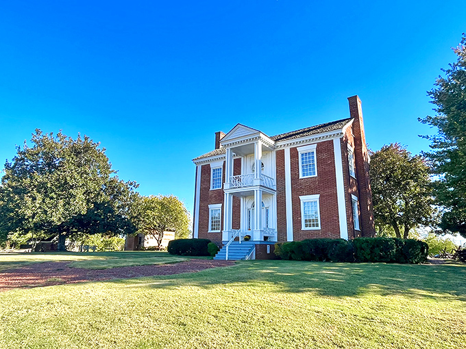 The Chief Vann House stands as an elegant testament to history, its red brick and white columns whispering stories from another era.