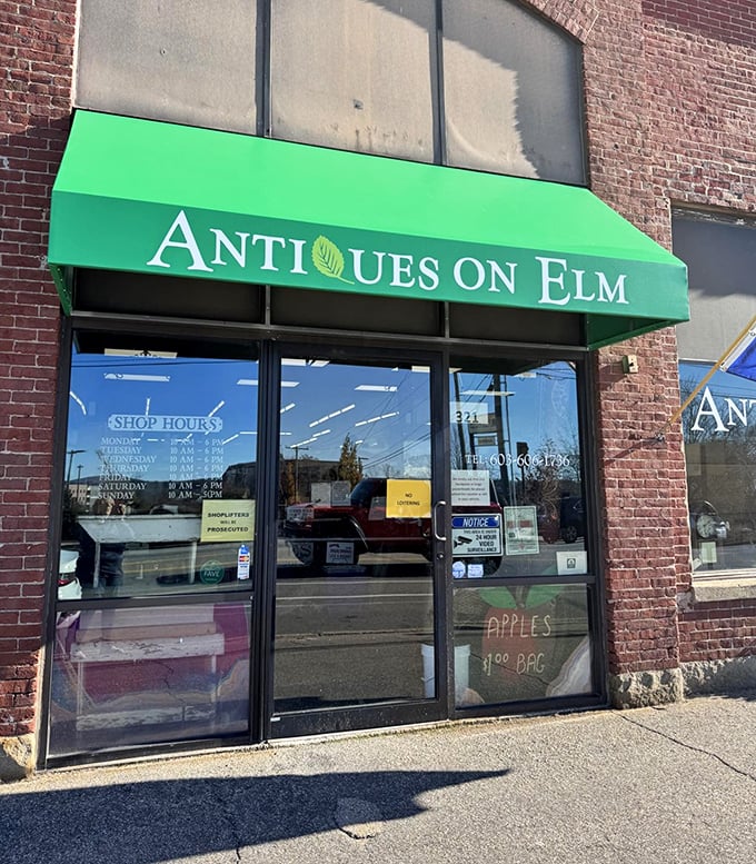 The vibrant green awning stands out against the historic brick like a beacon for treasure hunters. Shop hours posted clearly&mdash;because time-traveling requires proper planning.