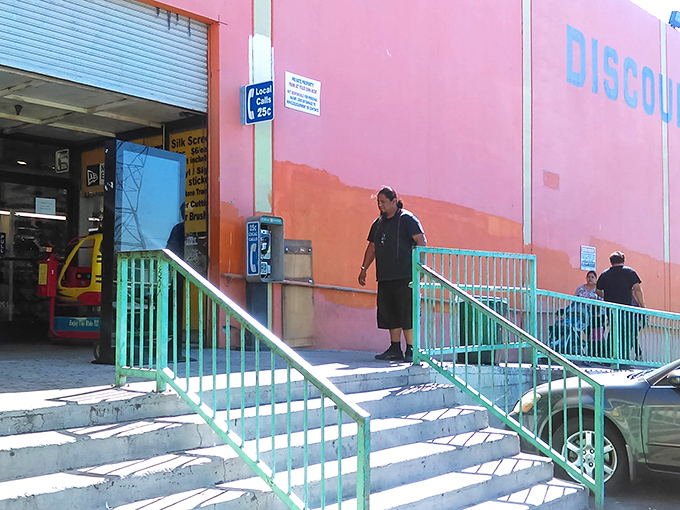 The mint-green railings and vibrant pink walls serve as your portal to bargain paradise. No ruby slippers required for this yellow brick road.