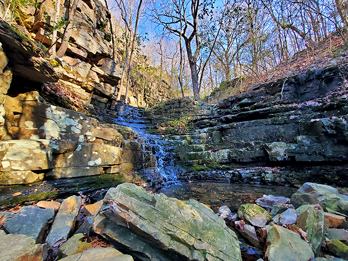 Nature's own staircase of stone and water. This hidden waterfall reveals itself to those patient enough to explore Emerald Park's quieter corners.