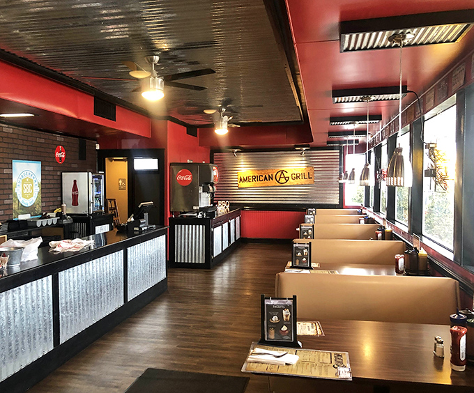 Red walls, corrugated metal, and wooden booths create that perfect balance of modern comfort and down-home BBQ joint authenticity.