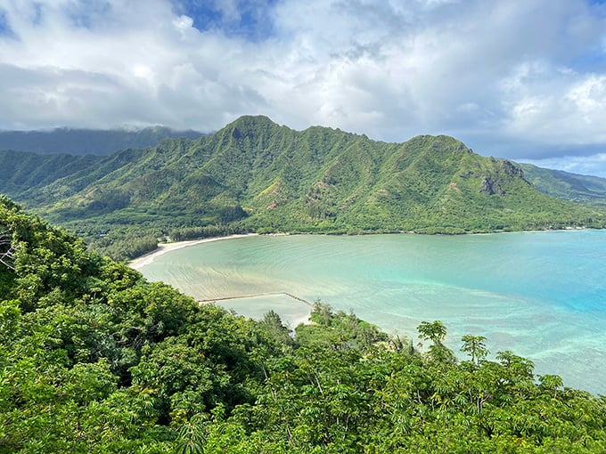 Nature's perfect postcard: the crystal waters of Kahana Bay embrace the shoreline while emerald mountains stand guard over this windward Oahu treasure.