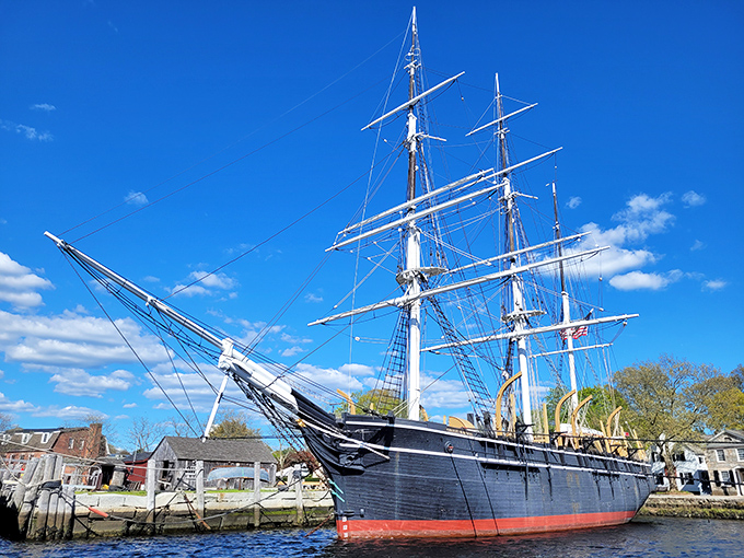 The Charles W. Morgan stands proud against azure skies, America's last wooden whaleship now peacefully docked. History you can touch, not just read about.