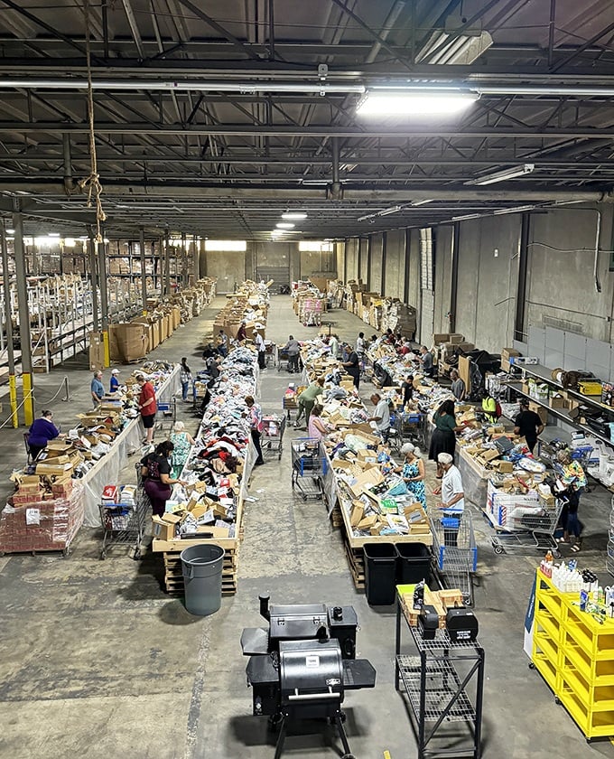 Treasure hunters in their natural habitat! The warehouse floor buzzes with energy as shoppers navigate tables piled high with potential finds. 