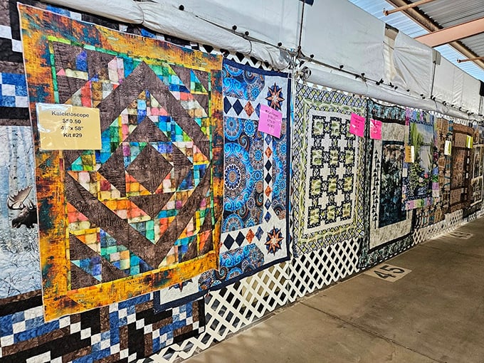 Handcrafted quilts hang like colorful canvases, each stitch telling a story of patience and artistry that no mass-produced bedding could ever match.