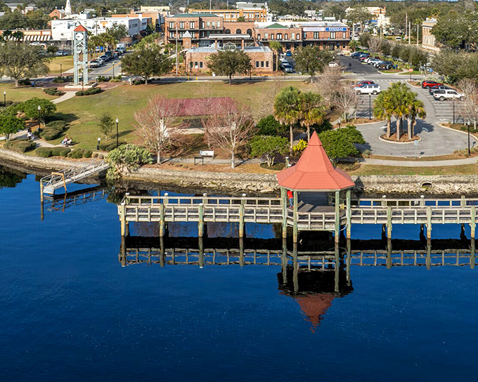 The iconic red-roofed gazebo stands sentinel over the St. Johns River, reflecting in waters that have witnessed centuries of Florida history.